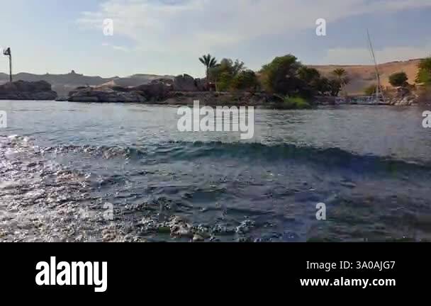 A serene view of the Nile River's blue waters under a gentle breeze ...