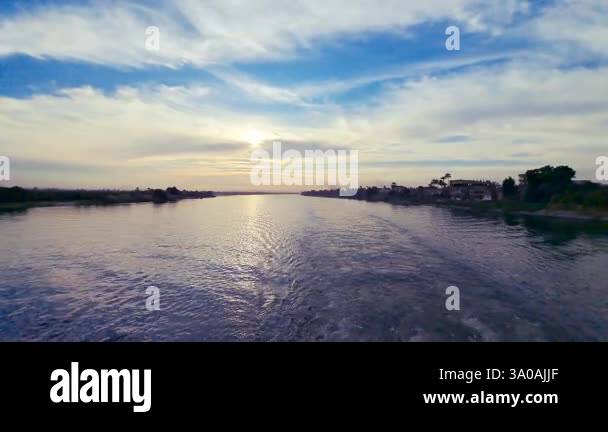 A breathtaking Nile River sunset with golden sunlight shimmering on ...