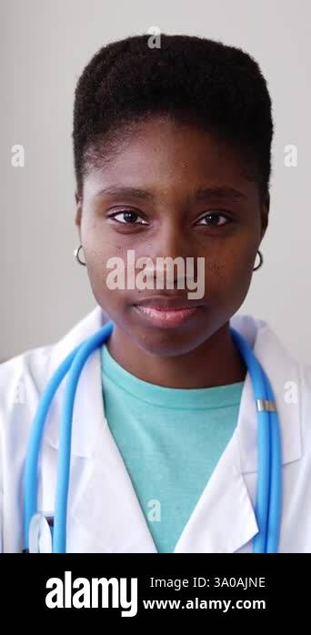 Portrait of young African female doctor looking seriously at camera ...