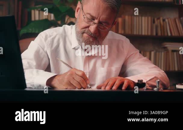 Aged senior old Caucasian man writing letter holding fountain pen paper ...
