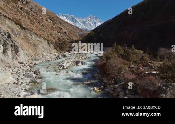 Mountain river cascading from Mount Everest, cutting through rocky ...