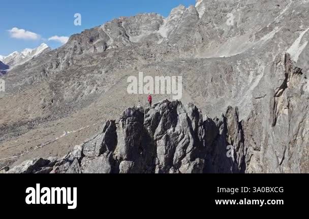 Mountain climber scaling precarious ridge, navigating rugged Himalayan ...