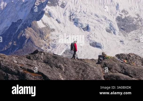 Experienced mountaineer traversing rocky Himalayan ridge, overlooking ...