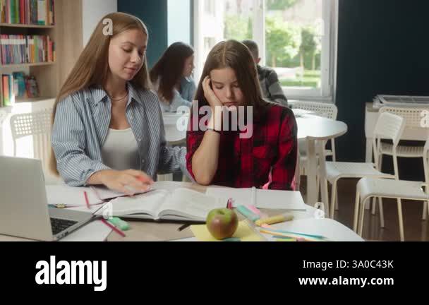 Two girls Caucasian women high school students pupils in classroom ...