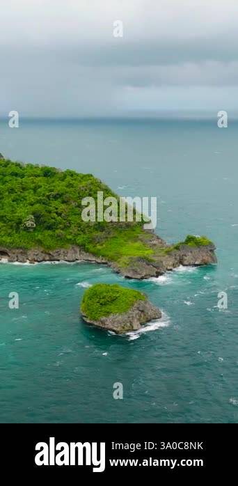 Ocean waves in Ilig Iligan Beach. Coastline with rocks and sand ...