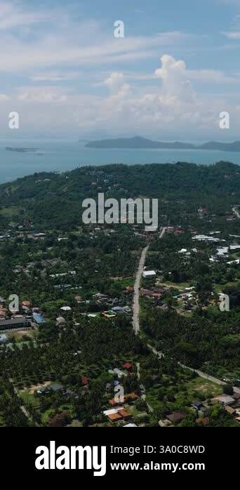 Scenic coastal town surrounded by greenery and turquoise waters under a ...
