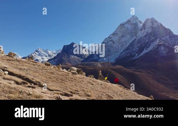 Mountaineer trekking narrow alpine path, towering Mount Everest ...