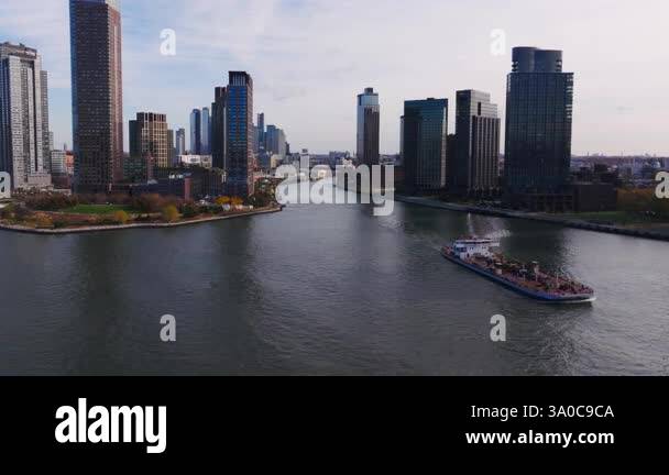 Aerial shots capture a barge moving goods along the East River, framed ...