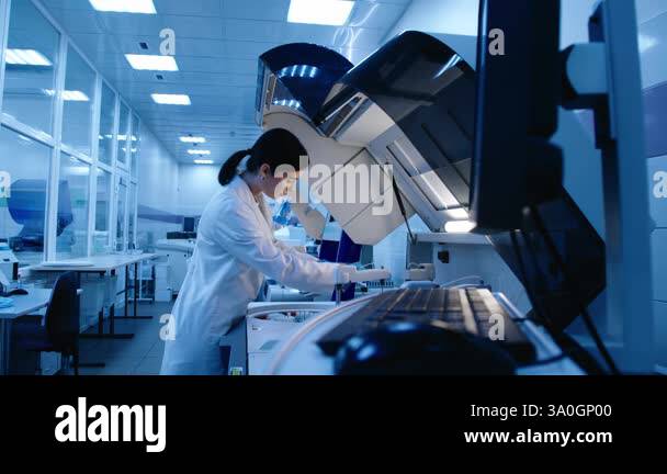 A scientist uses lab equipment for an experiment, working with test ...