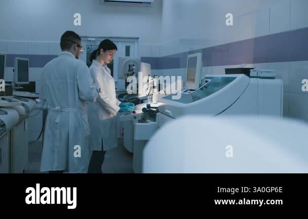 A team of scientists in gloves, glasses, and hats conducts biochemical research in a modern ...