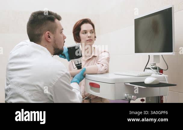 A dermatologist examines and analyzes the skin of a young patient in a ...