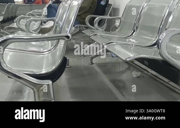 A perspective view of metallic chairs in a waiting area. The polished ...