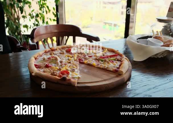 Close-up of beautiful, delicious pizza cut into slices and served in a ...