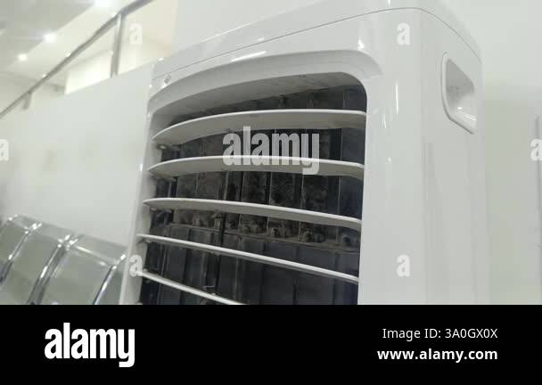 A detailed perspective of a tower fan reveals its louvered grill ...