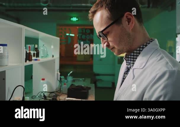 Footage of male scientist working late at night in laboratory with ...