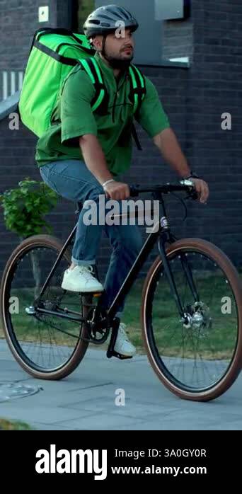 A cyclist in bright green gear is efficiently delivering orders in an ...