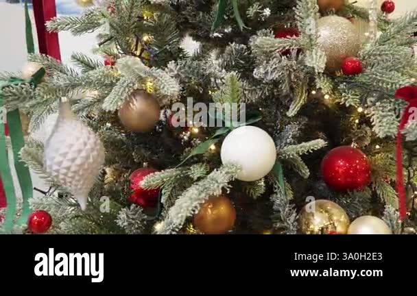 A beautiful Christmas tree adorned with golden and red ornaments glows ...