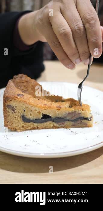 A fork is poised over a delectable slice of cake with layers Stock ...