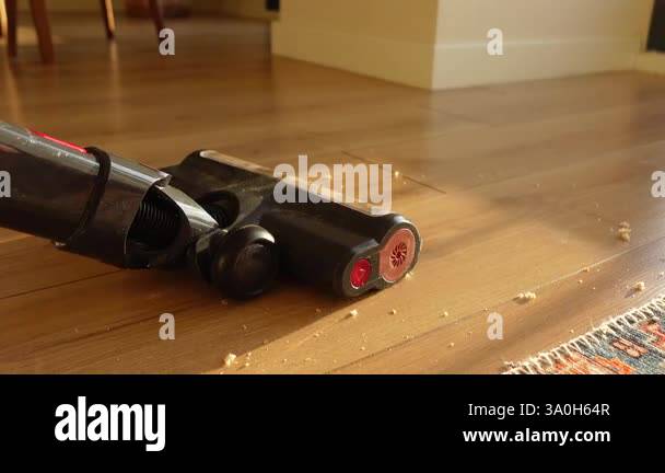 Vacuum is used to clean crumbs from a hardwood floor area Stock Video ...