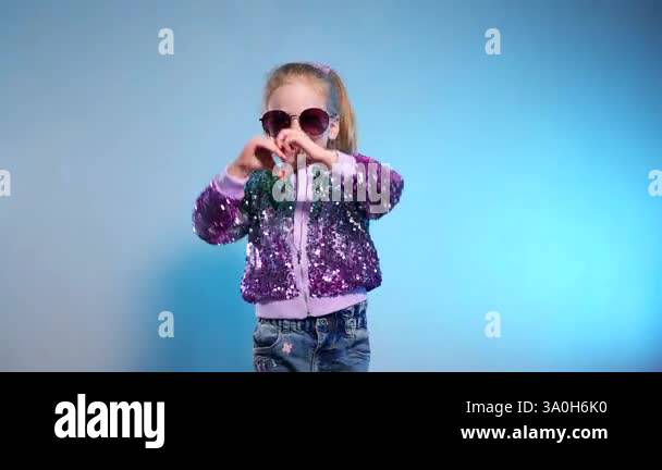 Smiling girl dancing funny in studio on colored background. Little ...