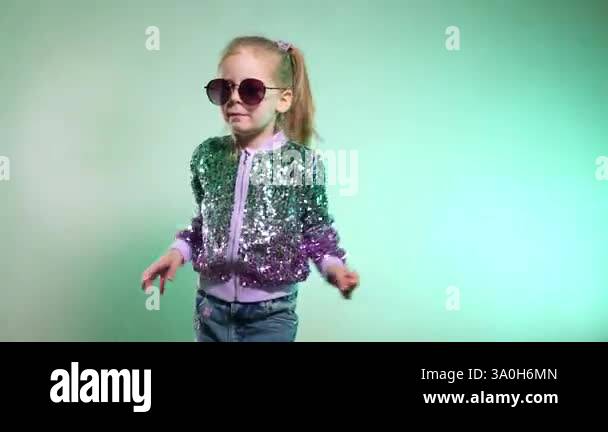 Smiling girl dancing funny in studio on colored background. Little ...