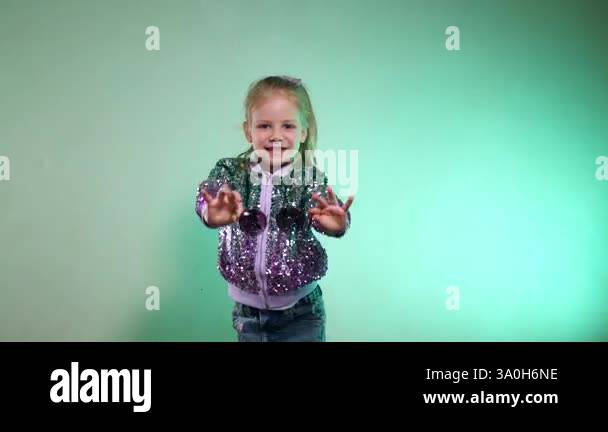 Smiling girl dancing funny in studio on colored background. Little ...