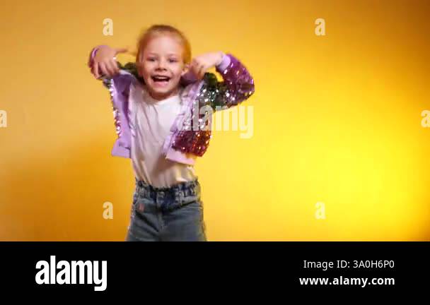 Smiling girl dancing funny in studio on colored background. Little ...