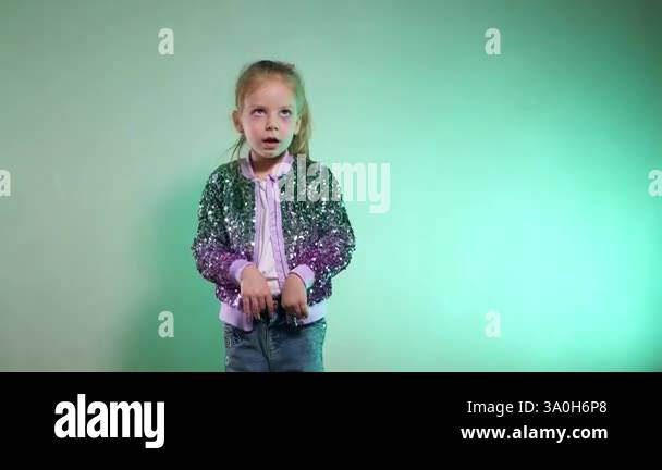 Smiling girl dancing funny in studio on colored background. Little ...