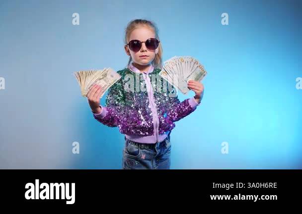 A young girl, dazzling in a sequined jacket, waves stacks of cash, fan ...