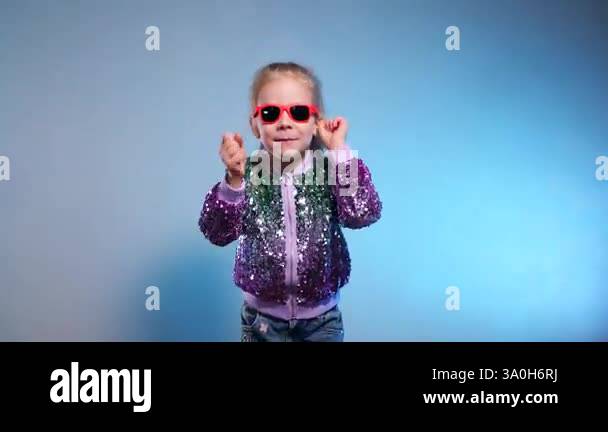Smiling girl dancing funny in studio on colored background. Little ...