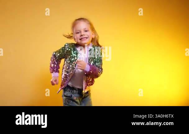 Smiling girl dancing funny in studio on colored background. Little ...