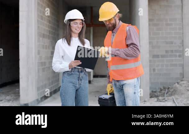 Workers discuss project details on construction site in slow motion ...