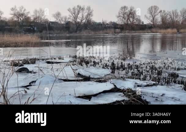 Winter landscape with ice on the river. Cracked ice on the lake. Frosty ...