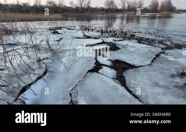 Winter landscape with ice on the river. Cracked ice on the lake. Frosty ...