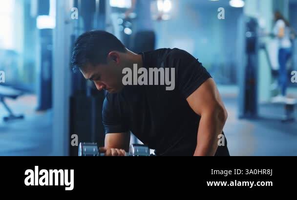 Portrait of concentrated exhausted asian man finishing training at the ...