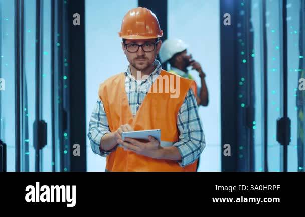 A diligent worker equipped with safety gear meticulously notes down ...