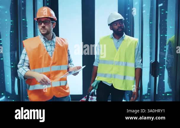 Two dedicated construction workers in safety gear focus intently on ...