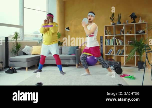 A lively video features two men working out in a cozy living room with ...