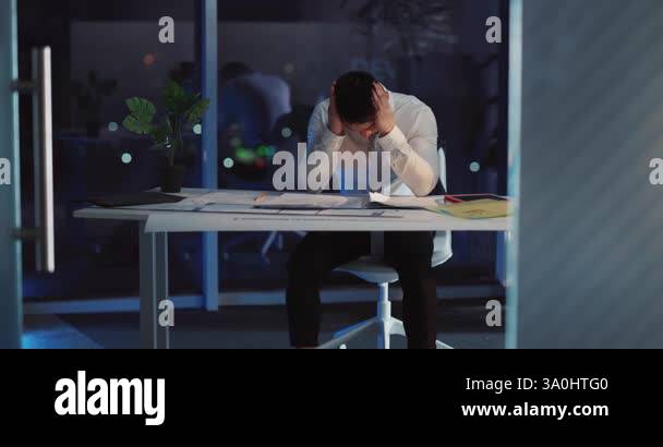 An exhausted office worker unmistakably exhibits severe signs of stress ...