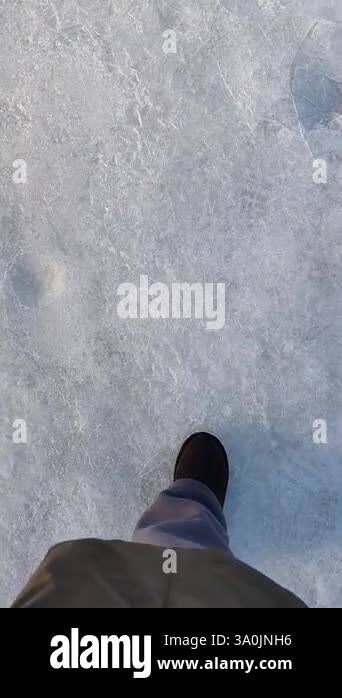 video of a girl walking on a frozen river, water. The ice creaks ...