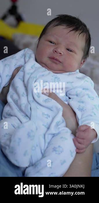 Newborn baby wearing a light blue onesie with delicate floral patterns ...