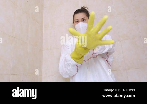 A cleaning specialist puts on protective gloves preparing for mold ...