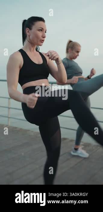 Dedicated woman performs leg kicks during a fitness session with a ...