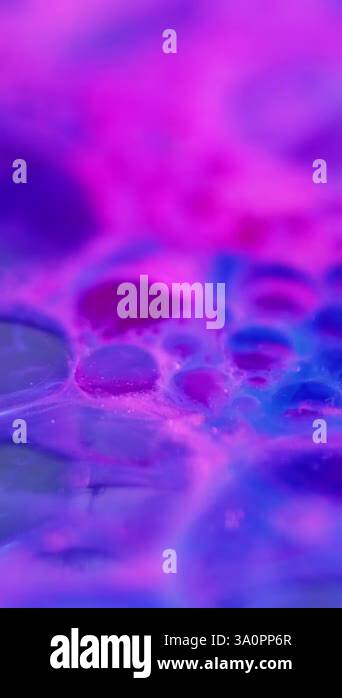 Vertical video. Bubble fluid. Wet foam. Defocused neon pink purple blue ...