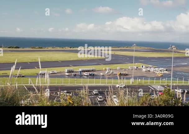 A scenic airport runway located by the ocean with clear blue skies. The ...