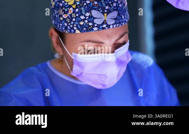 Face of female mid-aged Caucasian doctor in mask and cap. Portrait of a ...