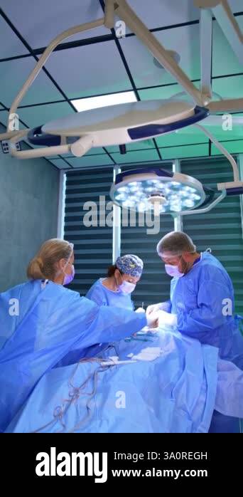Female nurse stands at the operating table preparing instruments for ...