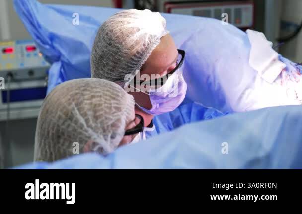 Shot over the head of two female surgeons wearing caps, protective ...