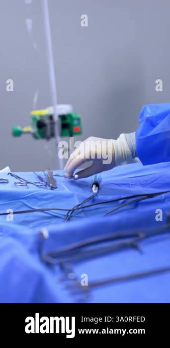 Hand in blue sleeve and white latex glove chooses a tool on the ...