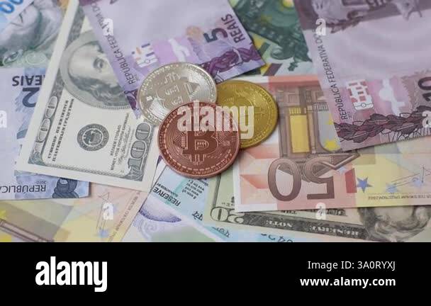 Round metal bitcoin on a background of paper banknotes of different ...
